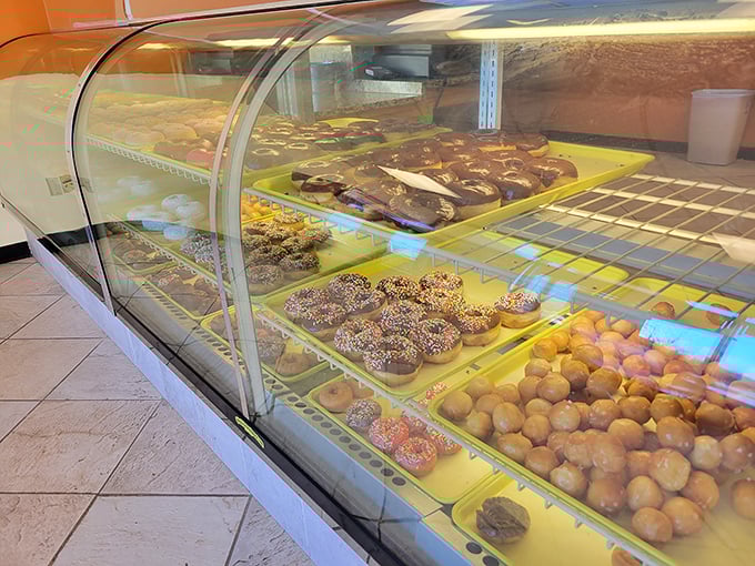 The display case—a gallery of edible art where every piece deserves your full attention. Choosing just one feels like Sophie's Choice: The Breakfast Edition.