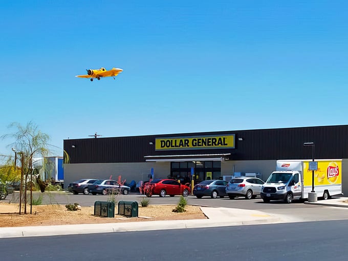 Dollar General's parking lot bustles with activity while a small plane soars overhead—two different modes of bringing necessities to this remote desert community.