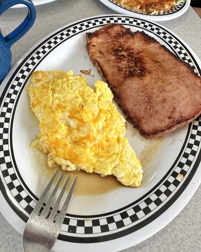 The classic breakfast duo – fluffy scrambled eggs alongside ham with just the right amount of caramelization on its edges.