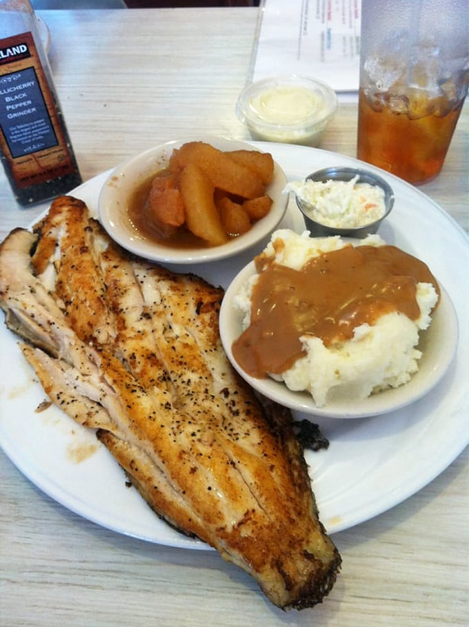 A perfectly grilled flounder filet alongside cinnamon apples and creamy mashed potatoes—proof that balance isn't just for yoga enthusiasts.