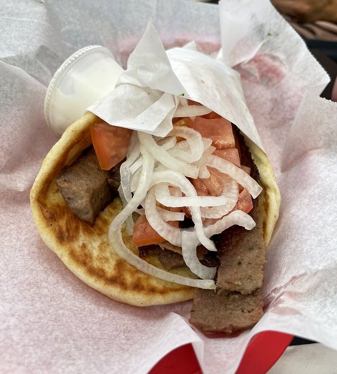 The gyro—where seasoned meat, fresh vegetables, and soft pita create a handheld masterpiece that transcends cultural boundaries and satisfies primal hunger.