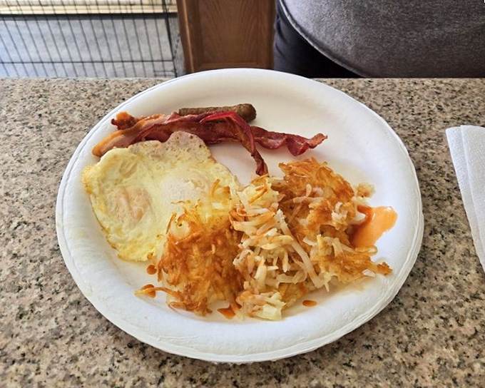 A plate that speaks the universal language of breakfast—crispy hash browns, sunny-side-up eggs, and bacon that means business.