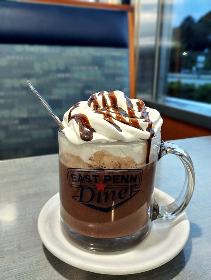 Hot chocolate elevated to an art form—whipped cream mountain, chocolate drizzle rivers, and that signature mug that says "you're home now."