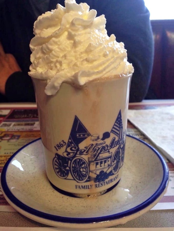 Hot chocolate that's more dessert than beverage, crowned with a cloud of whipped cream. The custom mug makes it taste even better – science can't explain why.