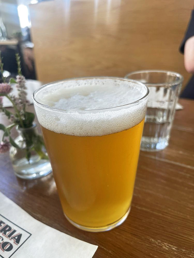 Golden, frothy, and perfectly poured—this craft beer is the liquid equivalent of a supporting actor who steals the scene from the pizza.