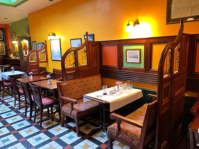 Warm yellow walls, rich wood accents, and patterned upholstery create a dining room that feels both special and comfortable—like dinner at a stylish friend's home.