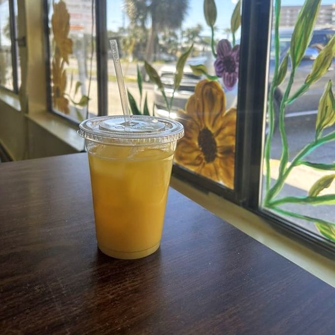 Fresh-squeezed orange juice catching the morning light through hand-painted sunflower windows – liquid sunshine in more ways than one. 
