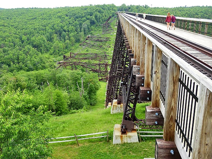 Visitors stroll along the remaining section of the once-mighty Kinzua Viaduct, now transformed into a pedestrian walkway with vertigo-inducing views below.