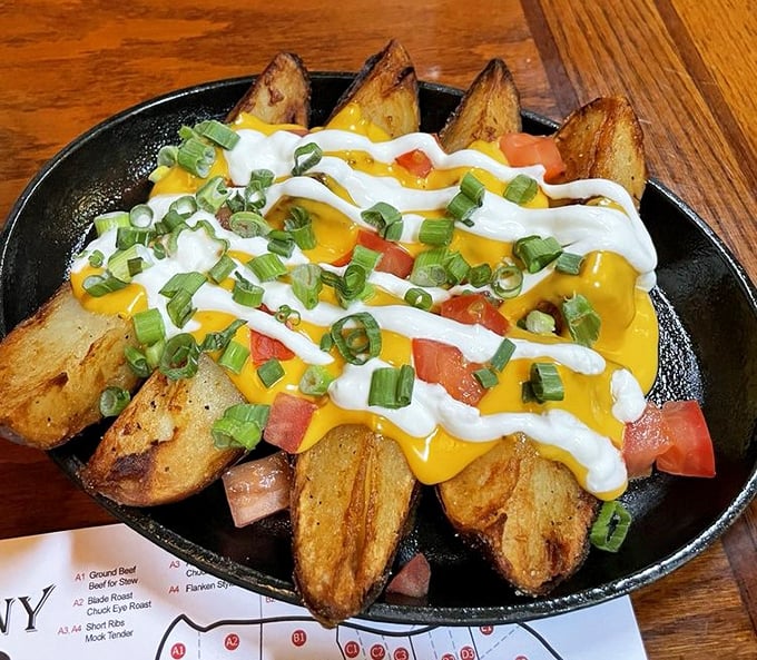 Potato wedges living their best life. Smothered in cheese, sour cream, and green onions—comfort food that refuses to be ignored.