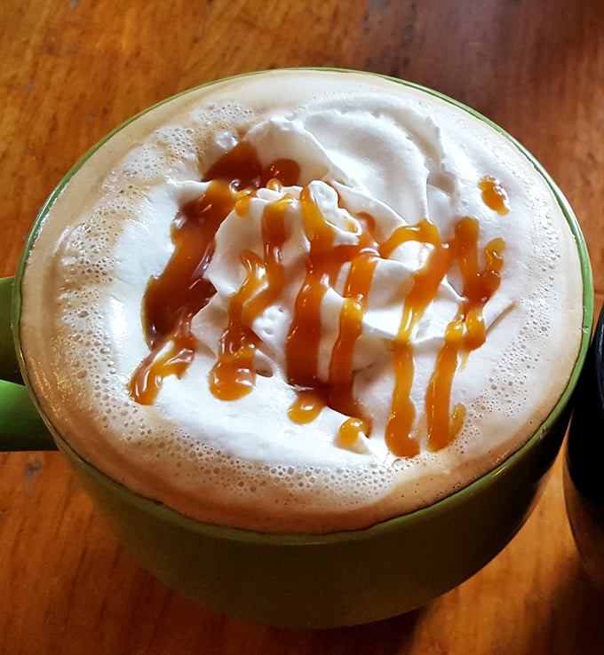 A latte that understands the assignment—foam art is nice, but that caramel drizzle is performing the real magic here. 