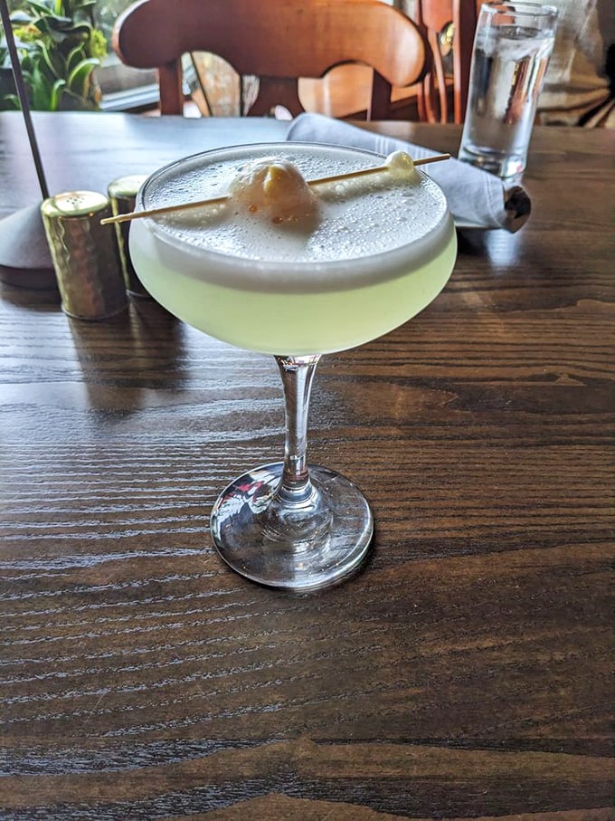 This cocktail isn't merely served – it's presented with the kind of foam cap and garnish that makes you pause to take a photo before the first sip.
