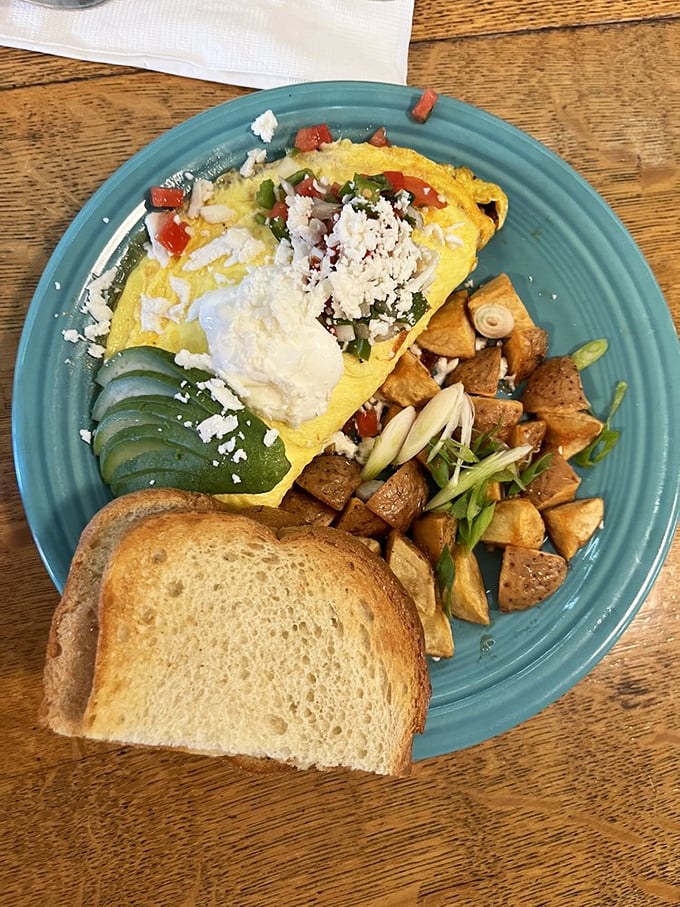 An omelet that doesn't just sit on the plate—it commands attention with vibrant colors and accompaniments that turn breakfast into an event.
