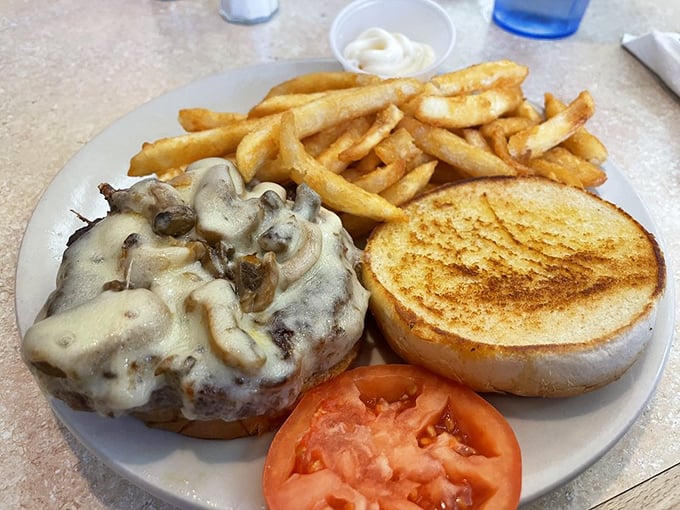 This mushroom Swiss burger isn't just lunch – it's therapy on a plate, complete with perfectly golden fries and a slice of summer-ripe tomato.