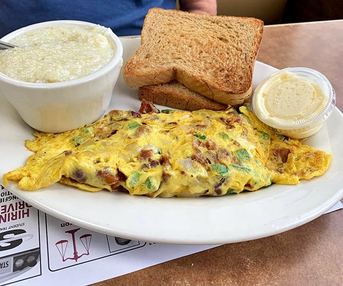 An omelet that's seen things – packed with fillings and served with grits that would make any Southerner nod in approval.