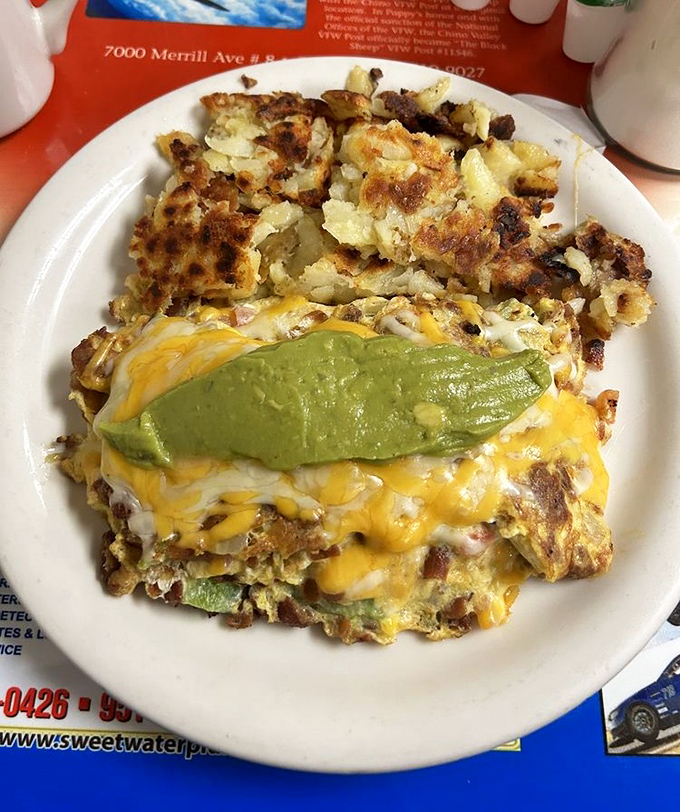 An omelet that doesn't just contain ingredients—it celebrates them, with melted cheese and avocado playing the starring roles in this breakfast drama.