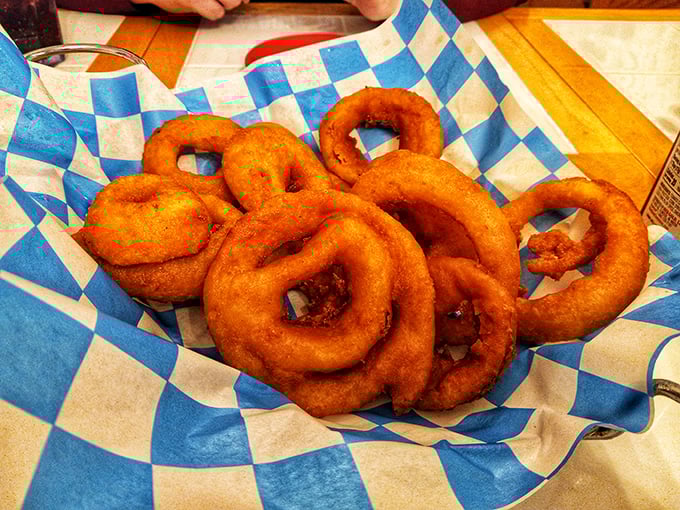 These aren't just onion rings—they're golden halos of happiness, perfectly crisp and served on that signature blue-checkered paper that screams "hometown diner."