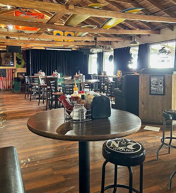 A rustic dining room that promises easy comfort, where bottles of hot sauce wait like sparks to ignite every bite.