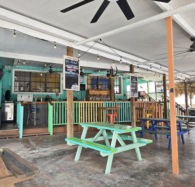 Colorful picnic tables that say "stay awhile" under a ceiling that's seen its share of sunset toasts and "you won't believe what I caught" stories.