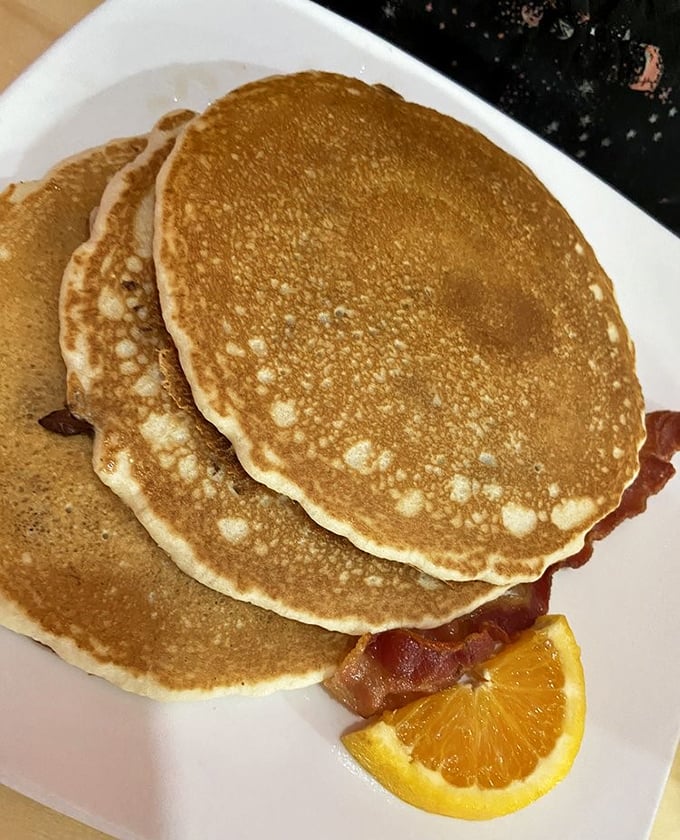 Pancakes stacked like golden records, each one a hit single in the breakfast hall of fame.