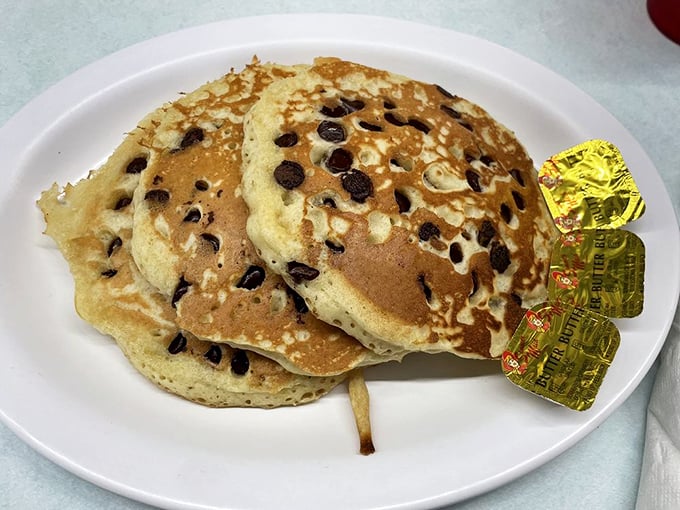 Chocolate chip pancakes that don't just satisfy hunger—they spark joy, especially with those little butter packets standing by like eager assistants.