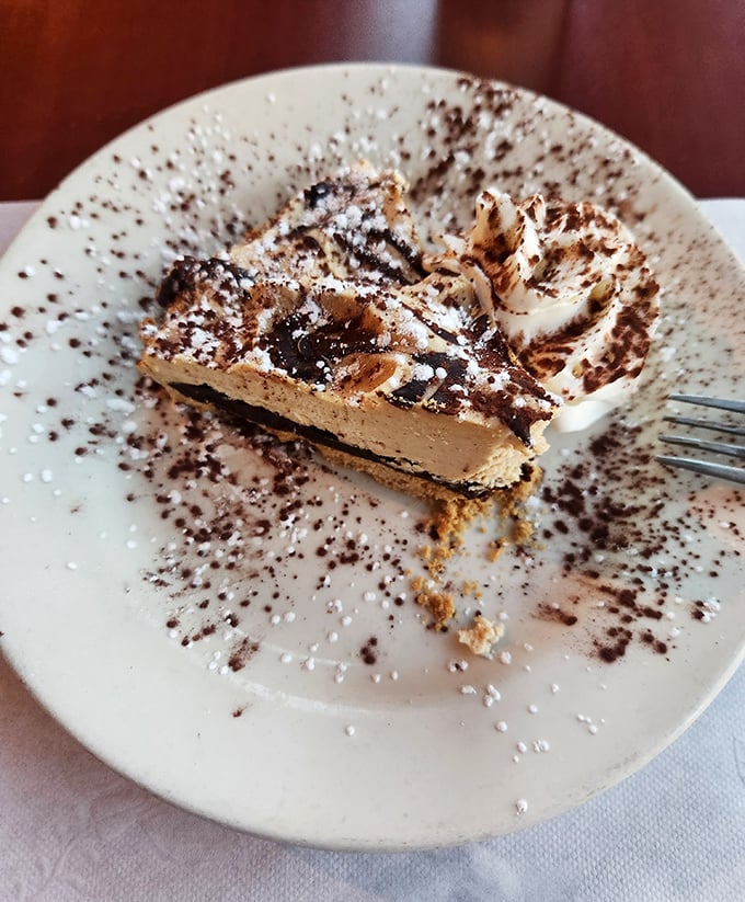 This isn't just dessert—it's a chocolate meditation with powdered sugar benediction. A sweet finale that demands you slow down and savor every forkful.