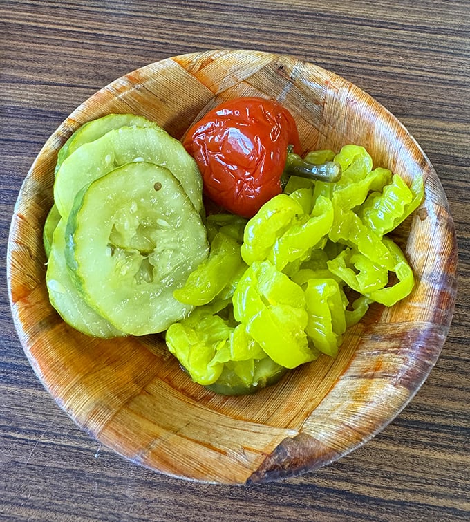 The pickle plate – nature's palate cleanser – offers tangy, crunchy respite between bites of cheesesteak, proving that supporting characters matter too.