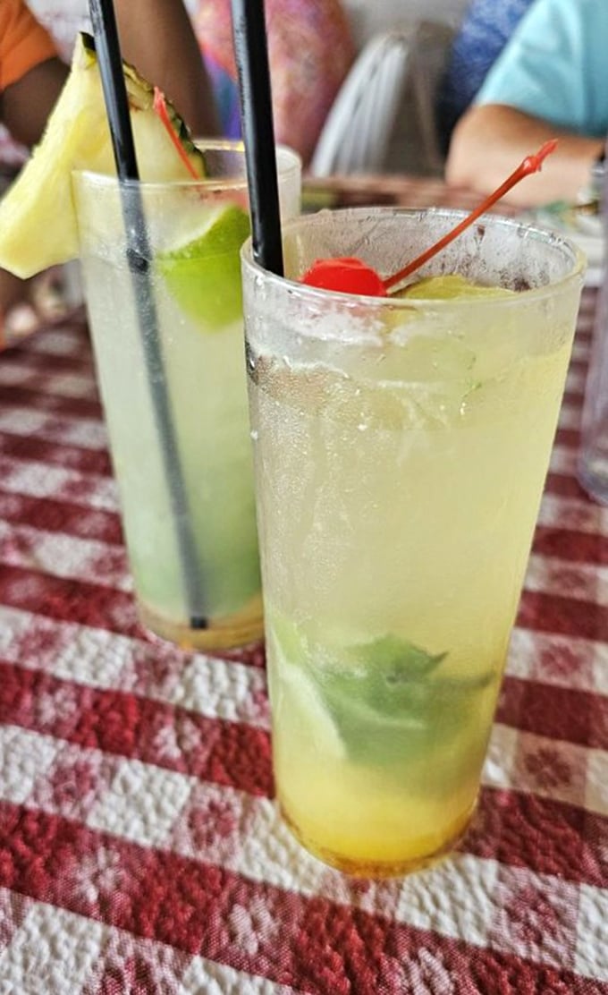 Cocktails that look like Florida sunshine in a glass. These mojitos aren't just drinks; they're vacation spirit guides with fruit hats.