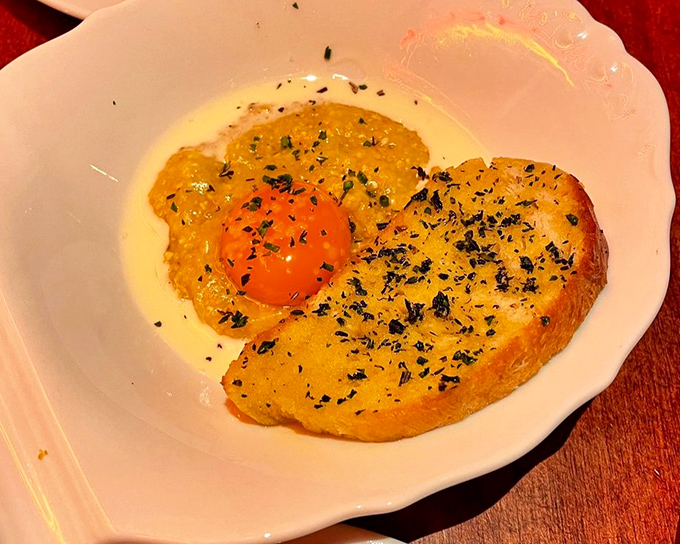 This isn't just polenta—it's comfort in carbohydrate form. That perfect egg yolk is nature's sauce waiting to be unleashed.