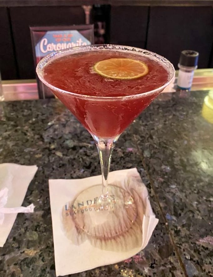 That ruby-red martini isn't just a drink—it's liquid entertainment with a citrus twist and a promise of good times ahead.