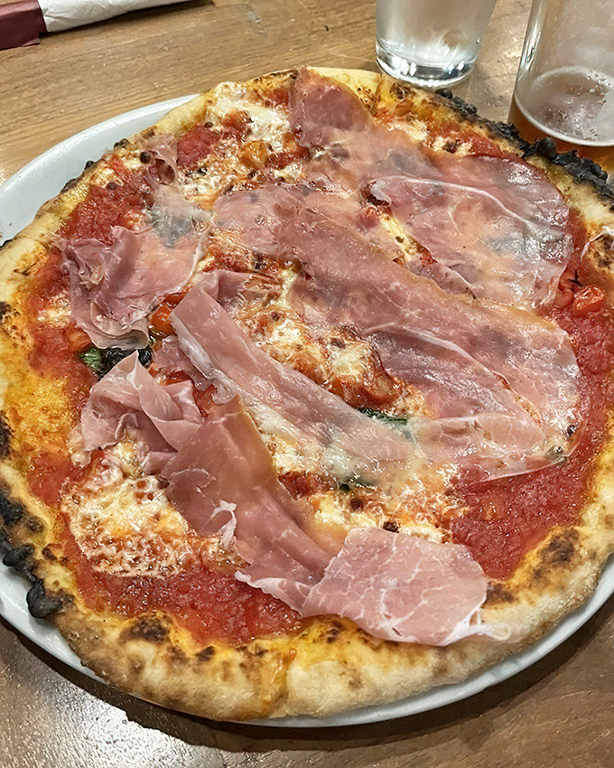Prosciutto draped like silk scarves over a pizza canvas. This isn't just dinner – it's the food equivalent of a standing ovation.