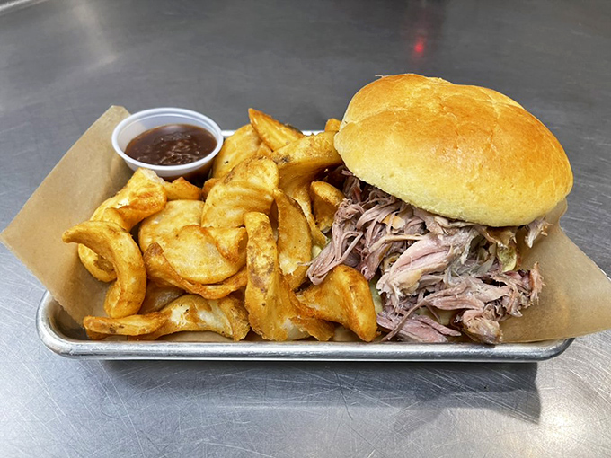 The pulled pork sandwich – a study in simplicity. Tender meat piled high on a soft bun with crispy potato wedges.