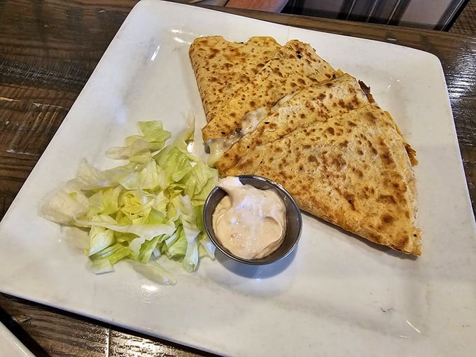 This quesadilla isn't playing games – golden-brown, stuffed with promises, and that dipping sauce is definitely not an afterthought.