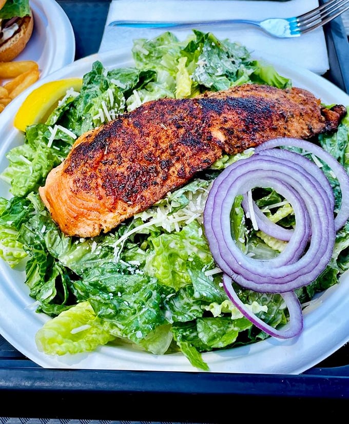 A perfectly blackened salmon filet atop crisp romaine—proof that salads don't have to be punishment. This is the kind of lunch that makes you feel virtuous and indulged simultaneously.