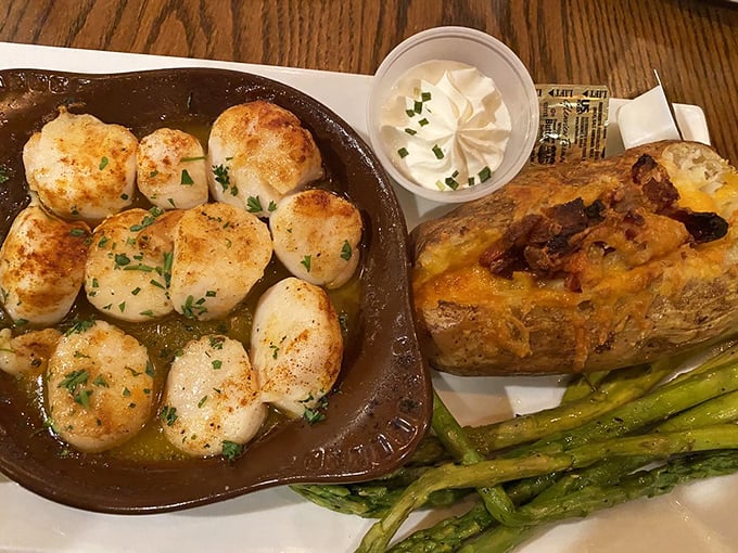 Sea scallops seared to caramelized perfection—ocean candy on a plate. That loaded baked potato is no slouch either.