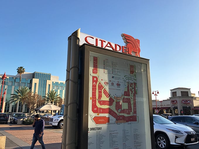 The directory sign stands like a retail lighthouse, guiding lost shoppers through the sea of savings with its illuminated map of temptation.