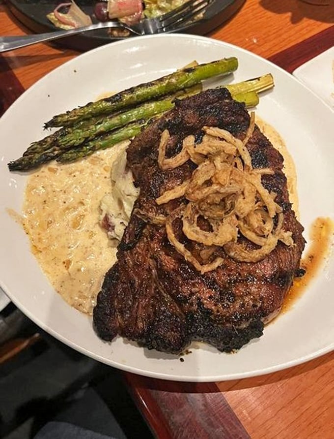 This isn't just steak—it's a blackened masterpiece with asparagus standing at attention, ready for your approval.