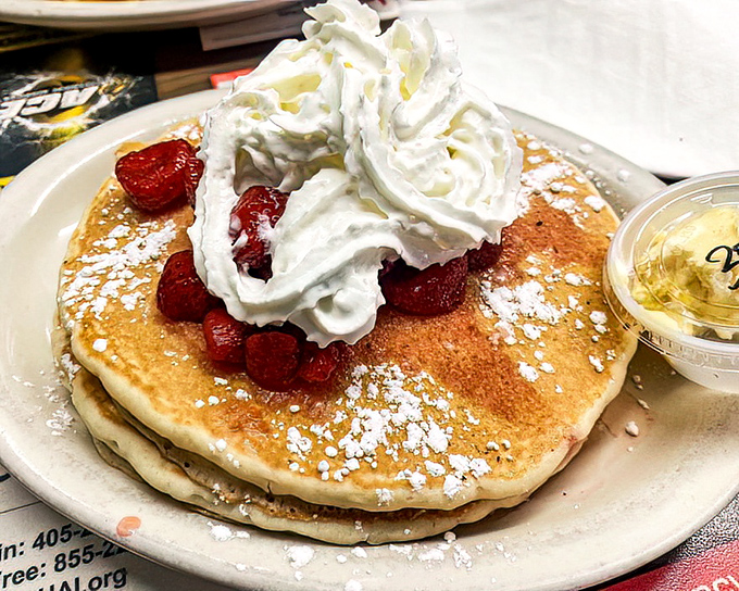 These pancakes aren't just breakfast – they're dessert with permission. The whipped cream mountain and strawberry valley create a landscape of pure joy.