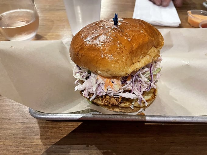 A sandwich that towers with ambition – crispy cutlet, vibrant slaw, and a bun that somehow manages to hold it all together.