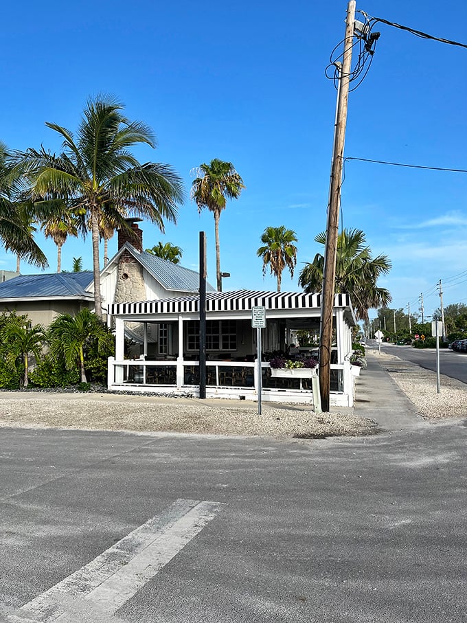 Palm trees frame this classic island eatery, where black and white awnings signal serious food in an unserious setting.