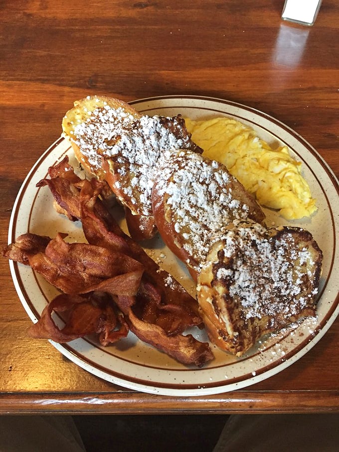 French toast that's dressed for success with powdered sugar, crispy bacon, and eggs—the breakfast equivalent of wearing a tuxedo to a pool party.