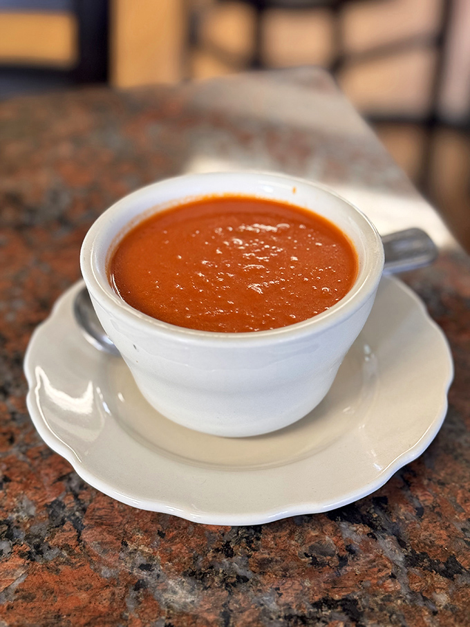 A cup of tomato soup that looks like it could cure whatever ails you. Smooth, vibrant, and waiting for its soulmate – the grilled cheese sandwich.