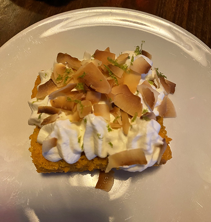 This dessert doesn't just end the meal—it provides closure in the most delightful way. Whipped cream and what appears to be candied citrus create sweet harmony.