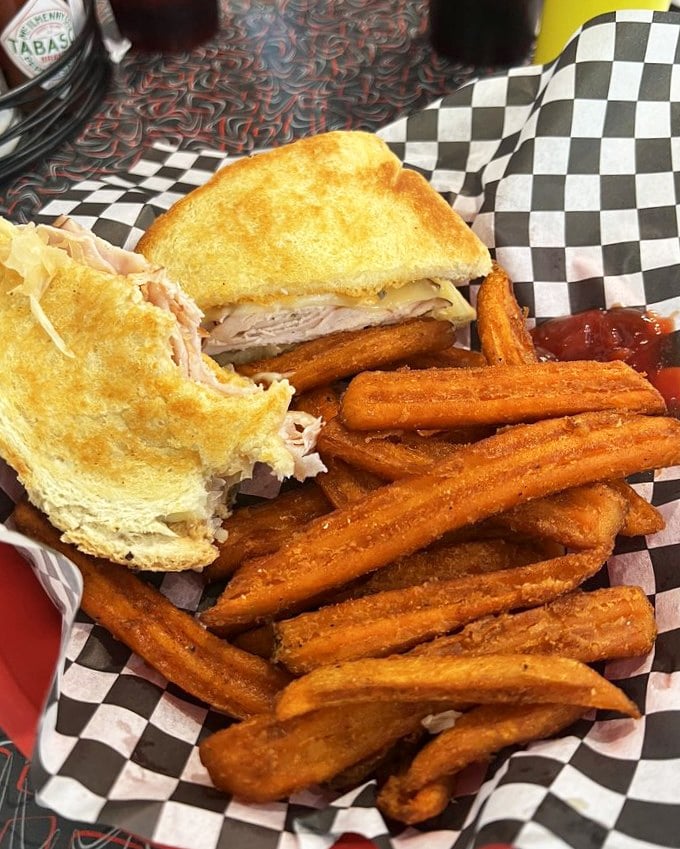 This sandwich isn't playing games—turkey, melted cheese, and those sweet potato fries on the side are staging a delicious rebellion against boring lunches.