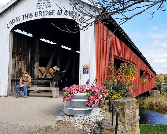 Two visitors pause at the bridge entrance, perhaps contemplating how many stories have crossed these planks since the days of Lincoln. 