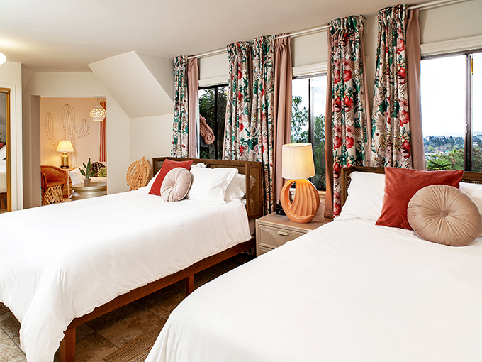 Twin beds never looked so inviting—floral curtains frame views of palm trees while cactus motifs remind you you're in California, not Camelot.