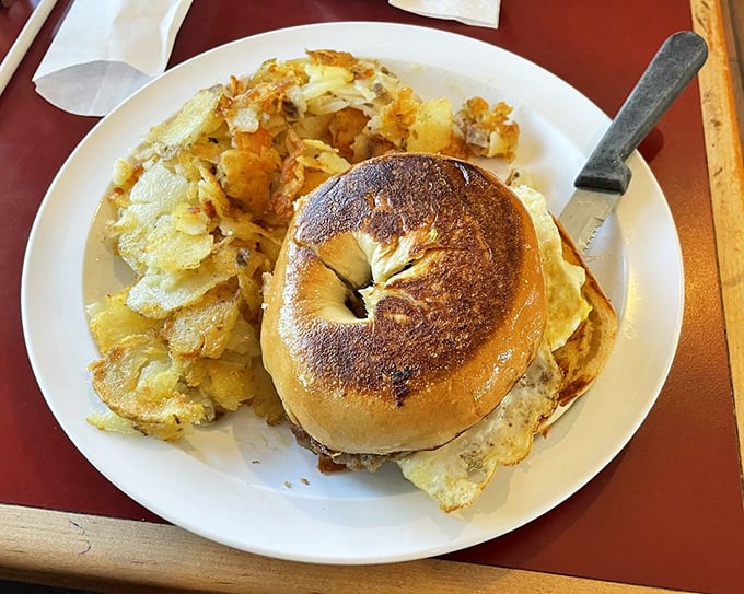 A toasted bagel sandwich with home fries that proves breakfast sandwiches don't need to be grabbed on-the-go to be life-changing.