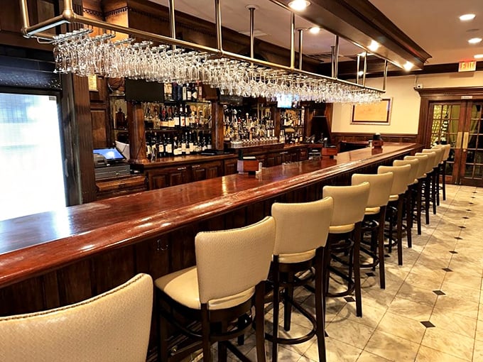The bar gleams with polished wood and hanging glassware that catches the light like crystal chandeliers. A perfect perch for pre-dinner cocktails or solo dining.