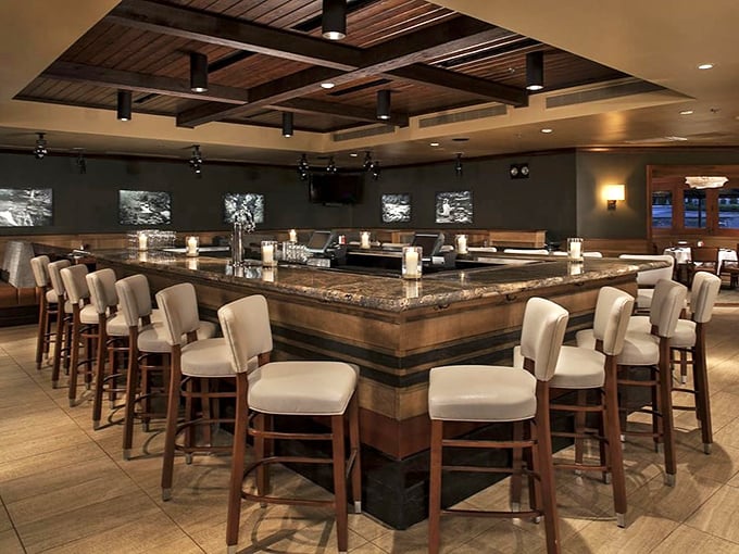The bar area combines warm wood, cool stone, and comfortable seating—the trifecta of "I came for one drink but might stay until closing time."