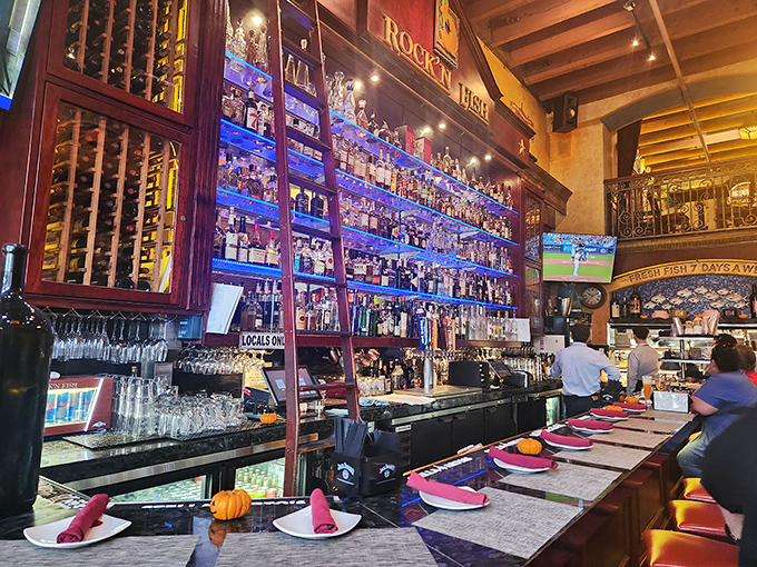 A backlit bar that would make a Broadway stage designer jealous. Those bottles aren't just spirits—they're the supporting cast in your dining adventure.