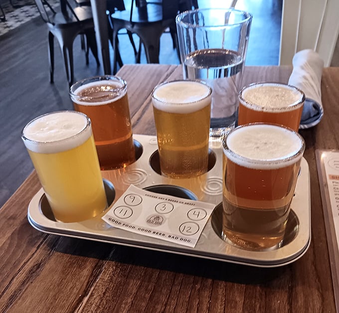 The beer flight board—where indecision becomes a virtue. Six different brews lined up like liquid soldiers ready for your tasting adventure.